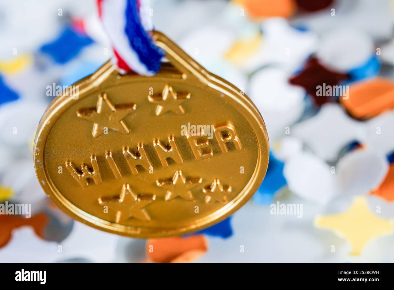 Winner symbol photo of a gold medal with winner inscription on confetti ...