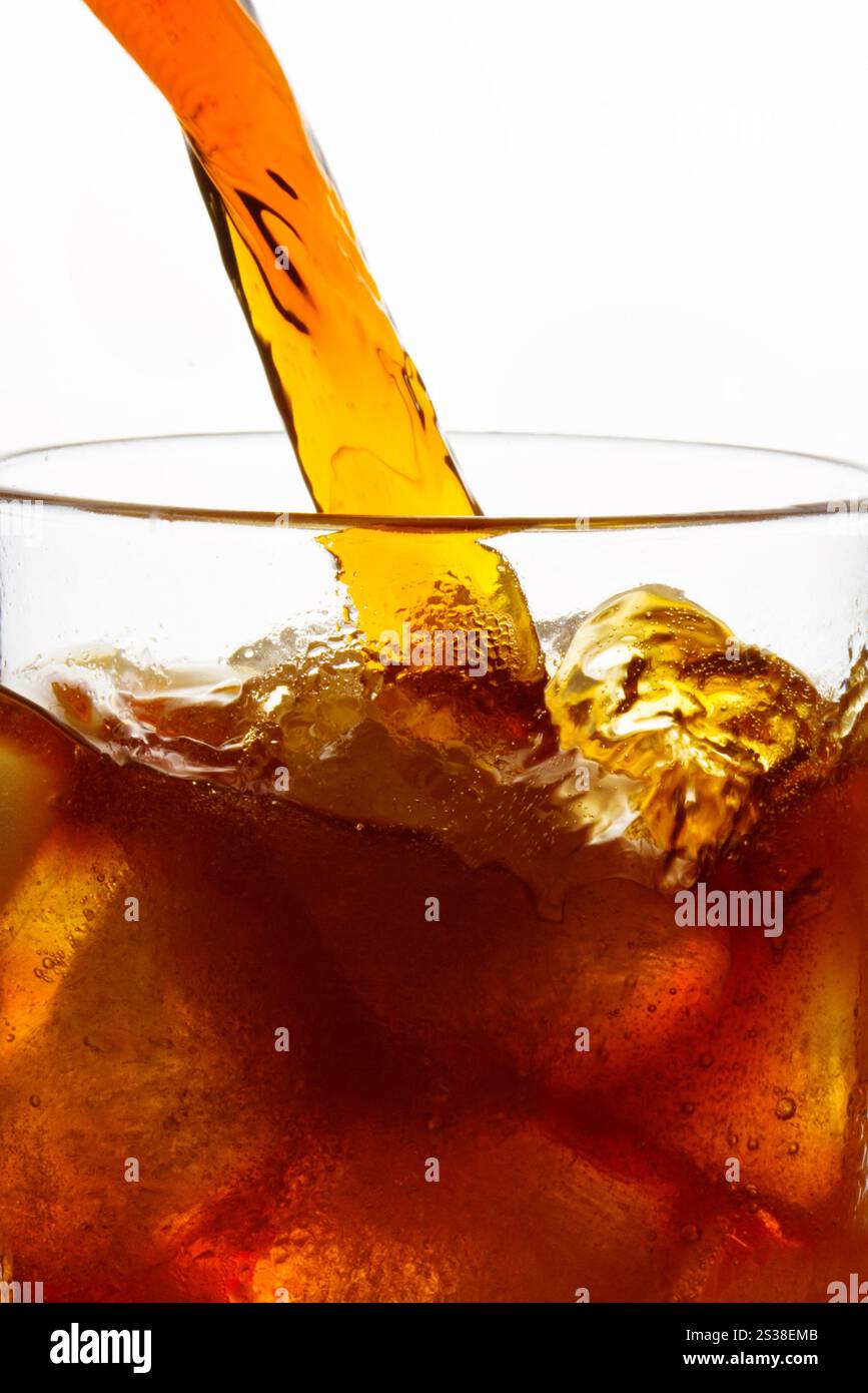 Cola is pouring into glass on white background. Cola is pouring into ...