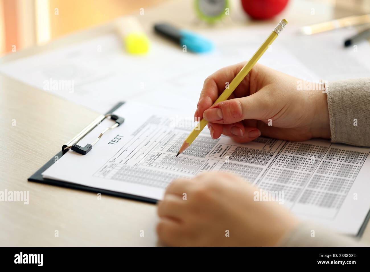 Female student hands testing in exercise and taking fill in exam paper ...
