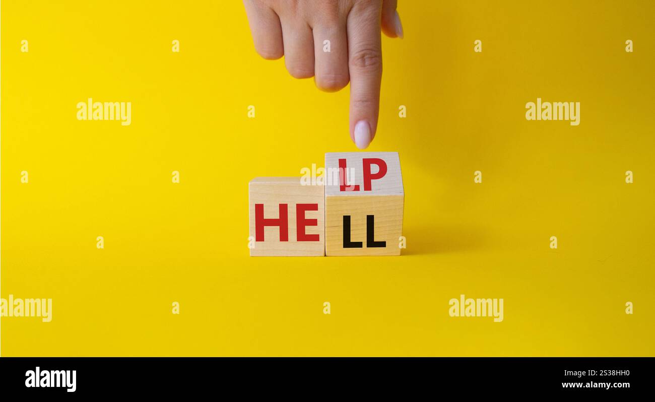 Help vs Hell symbol. Businessman hand points at turned wooden cubes ...