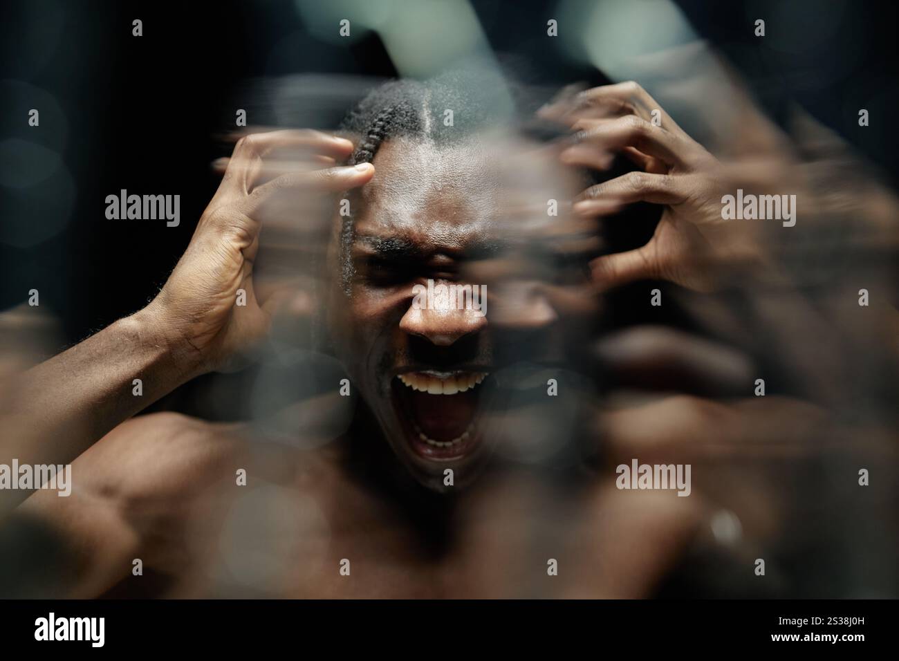 Portrait of Black man furiously screaming holding head with hands ...