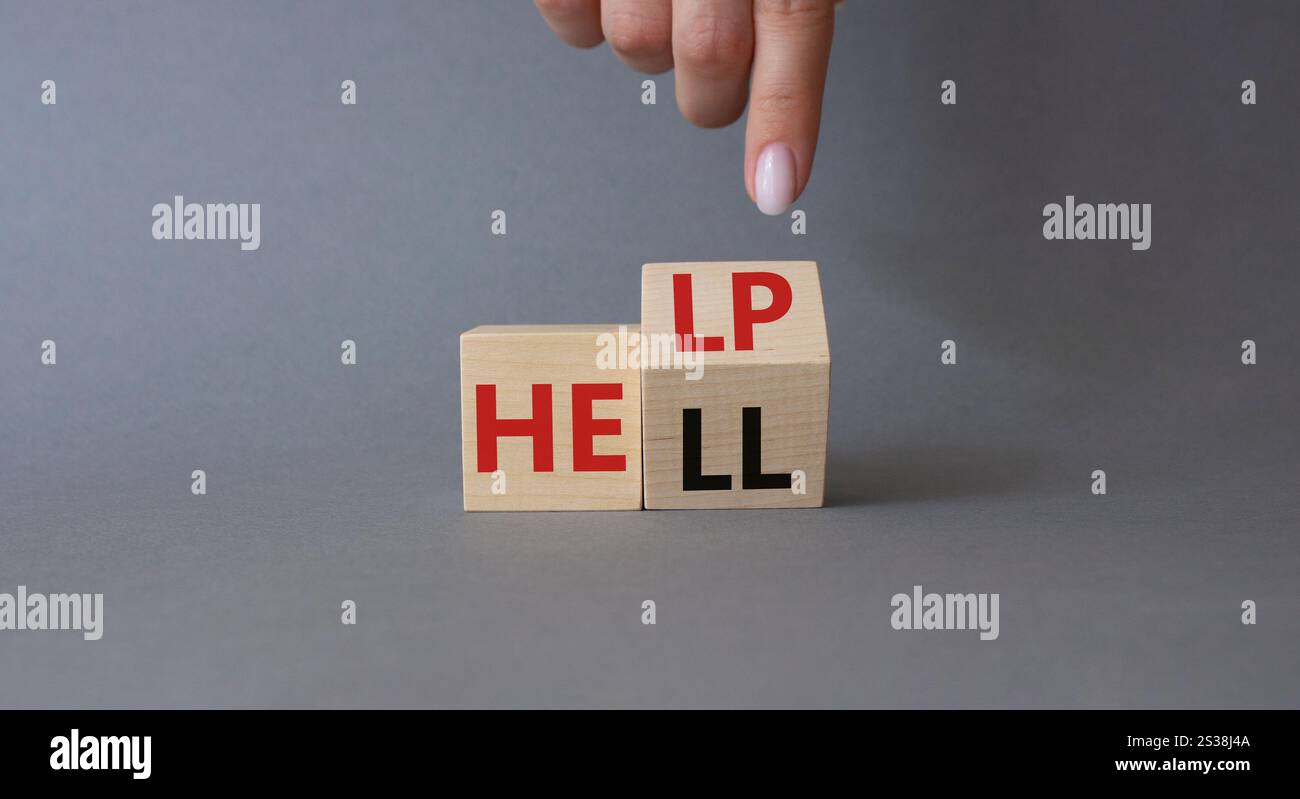 Help vs Hell symbol. Businessman hand points at turned wooden cubes ...