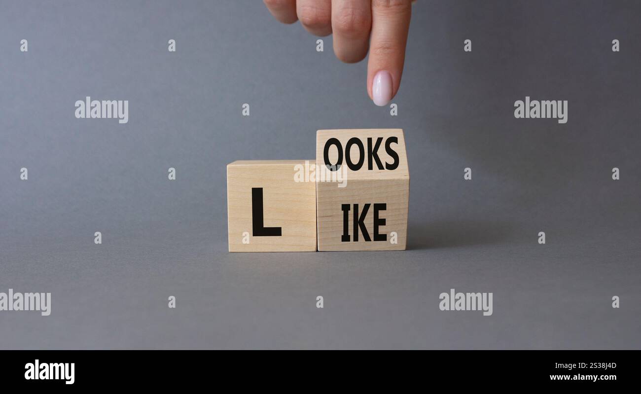 Looks like symbol. Businessman hand points at turned wooden cubes with ...