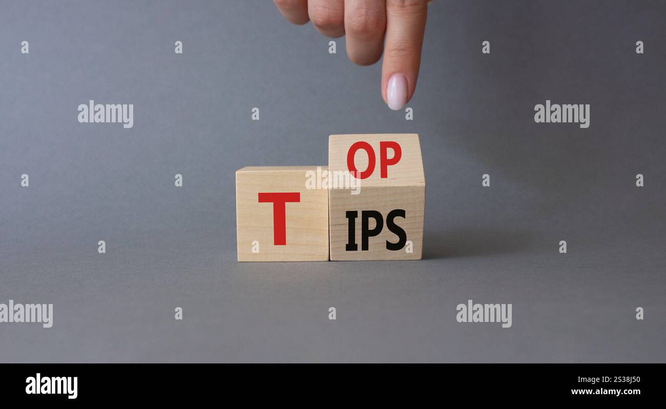 Top Tips symbol. Businessman hand points at turned wooden cubes with ...