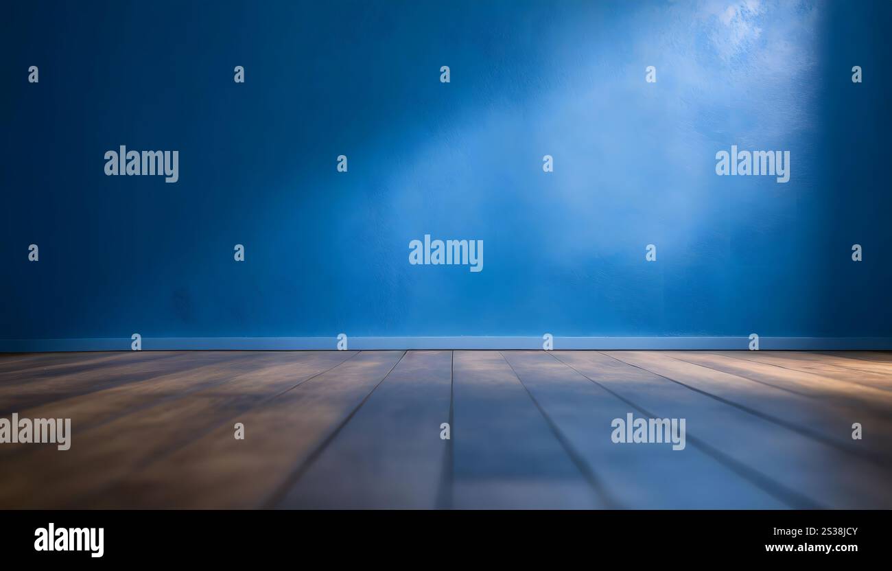 An empty room with a striking blue wall and a warm wooden floor. The ...