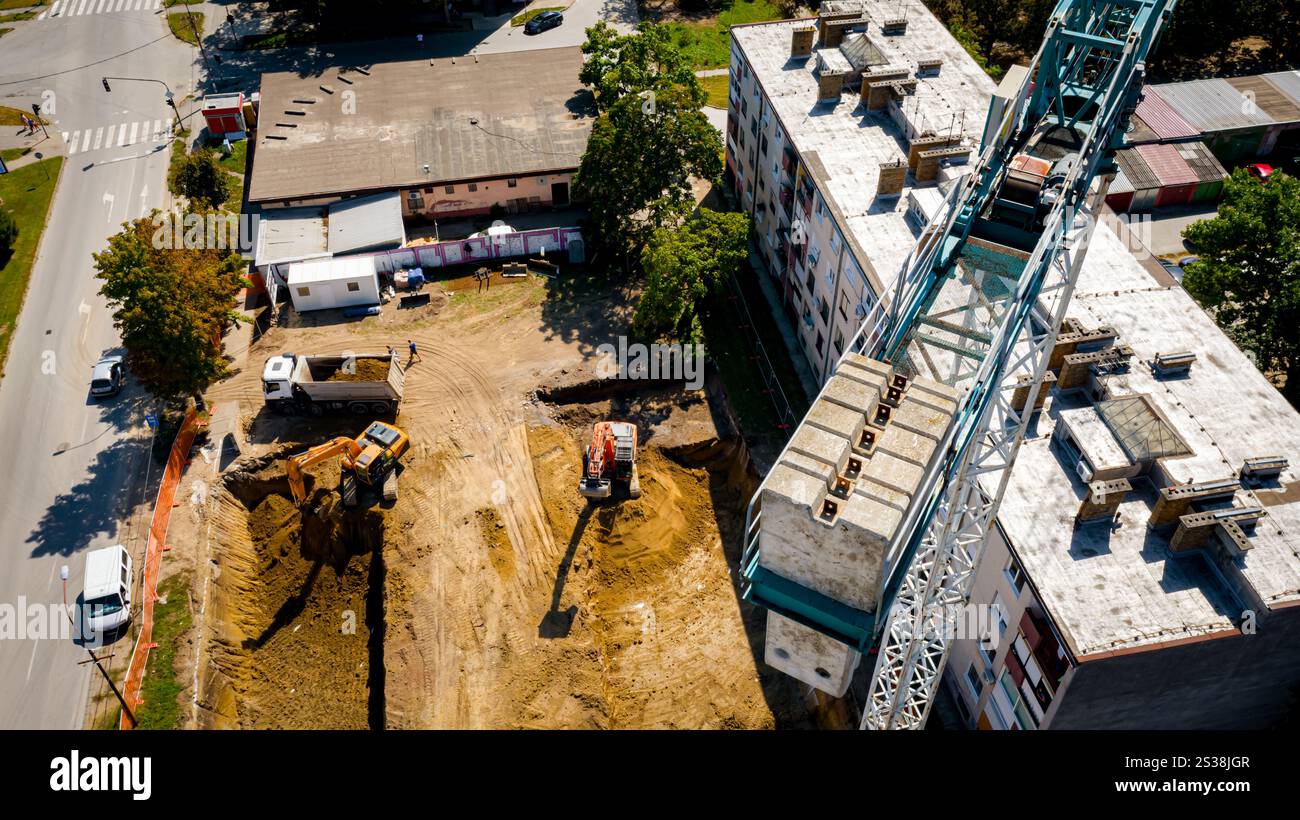 Above view on two excavators as digging, excavating foundation for residential building and ...