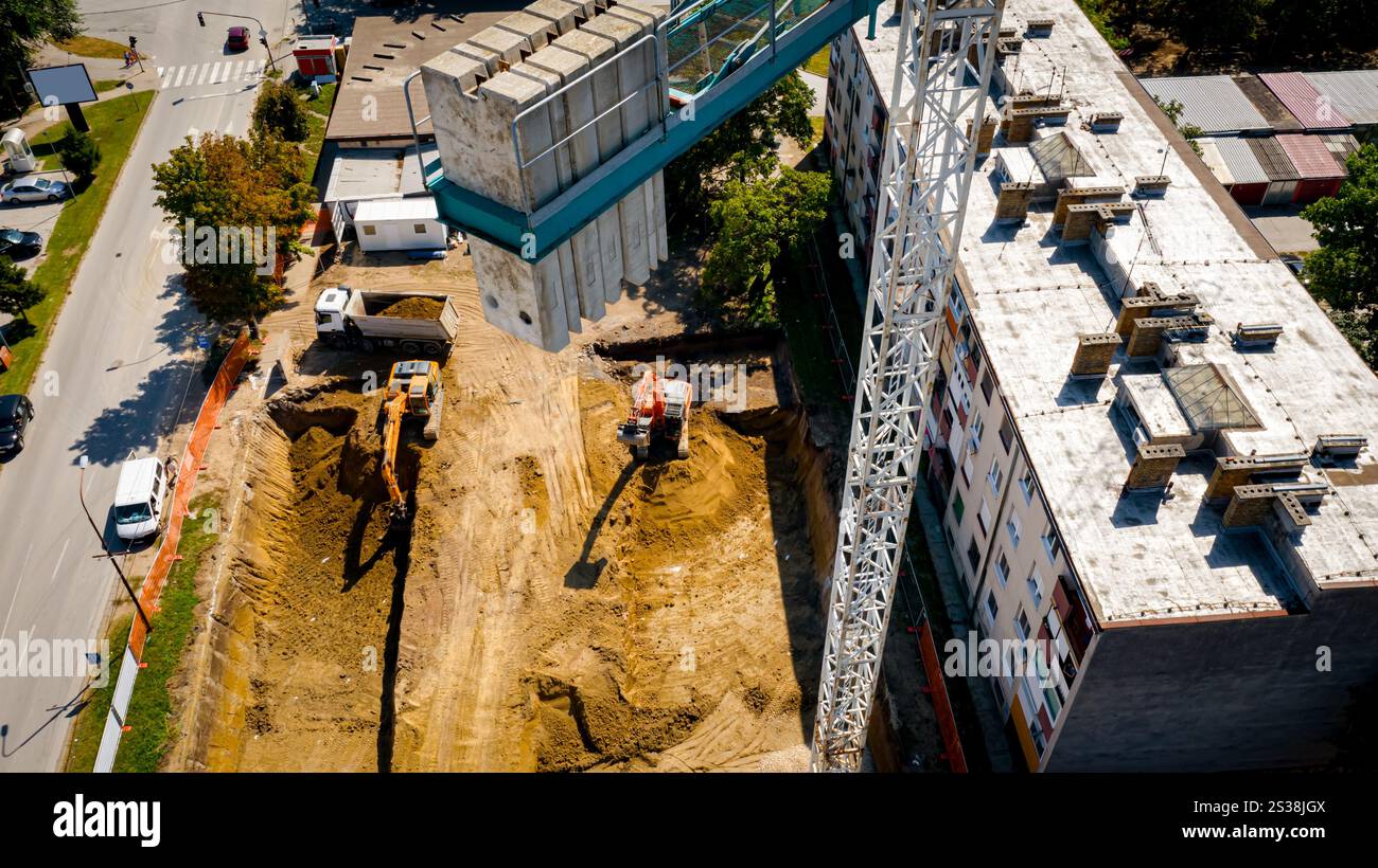 Above view on two excavators as digging, excavating foundation for residential building and ...