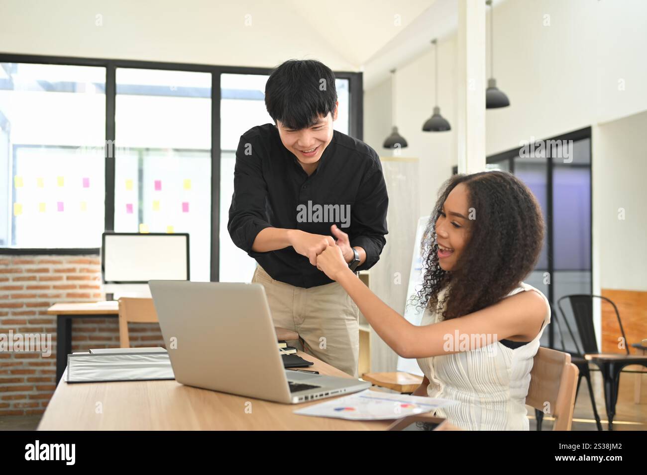 Young businesspeople celebrating breakthrough or positive results on ...