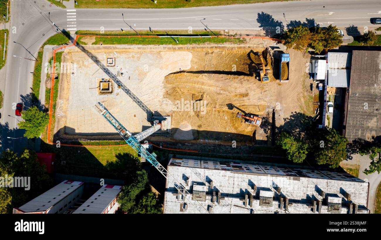 Above top view on two big excavators as they digging, excavating foundation for new residential ...