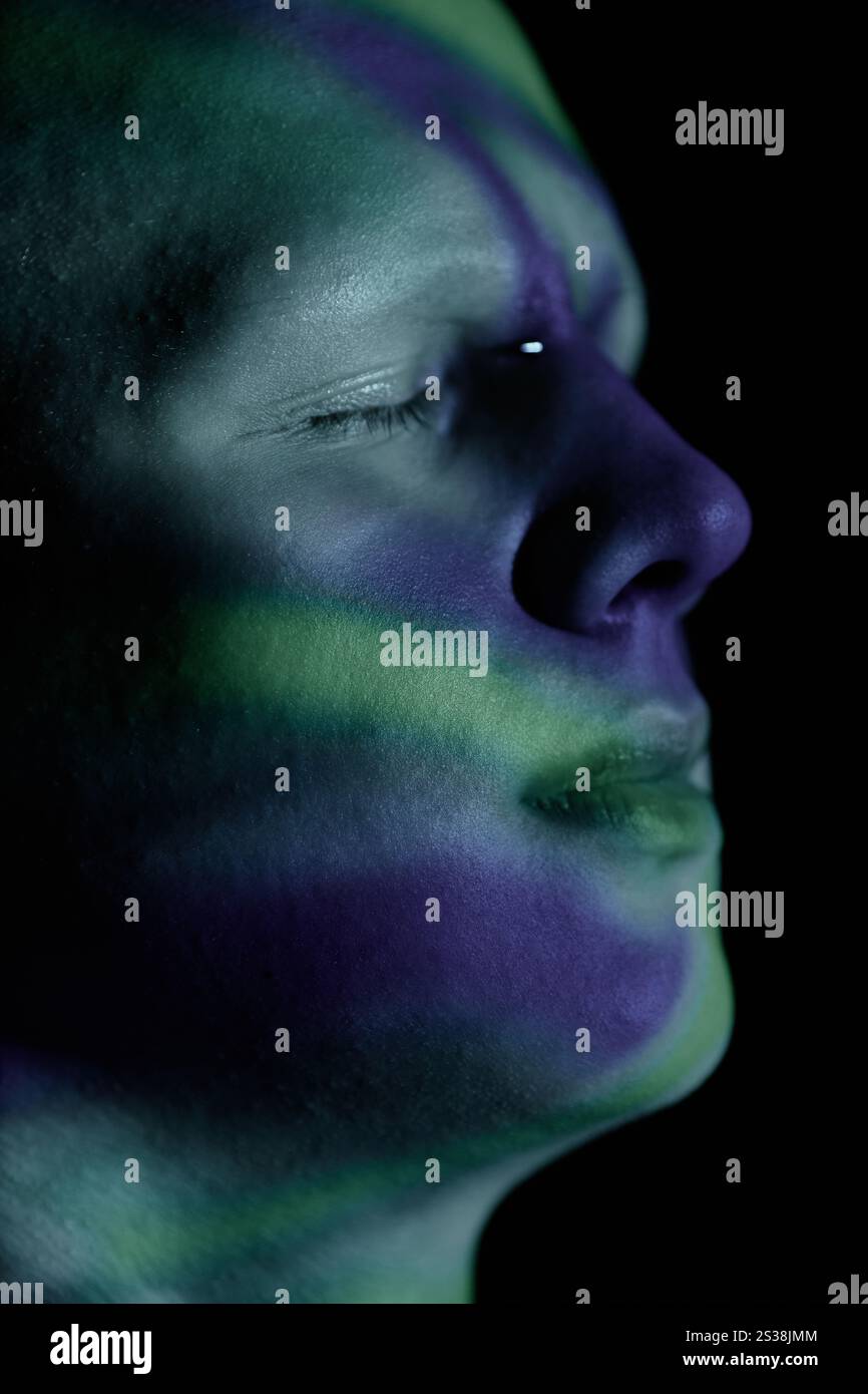 Extreme close up of man with eyes closed drown in thoughts with blue ...