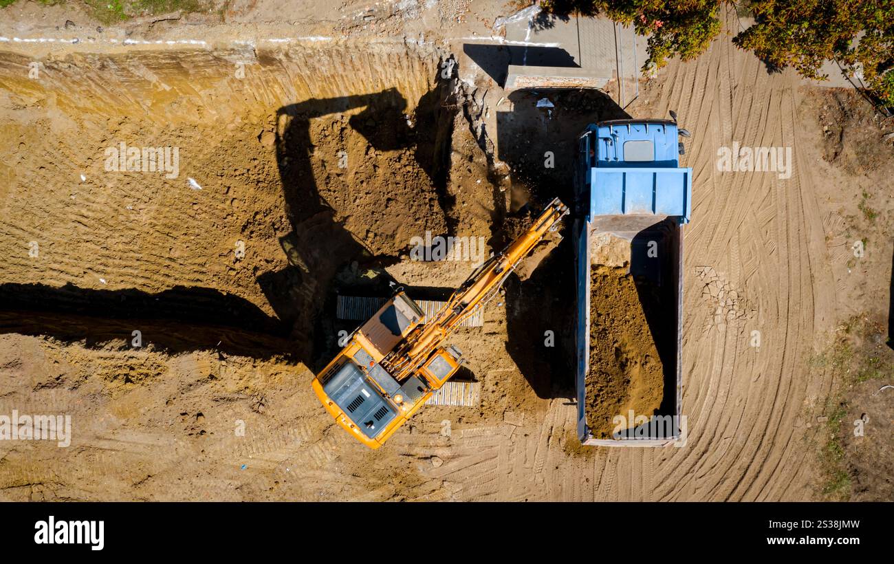 Above top view on big excavator as digging, excavating foundation for new residential building ...