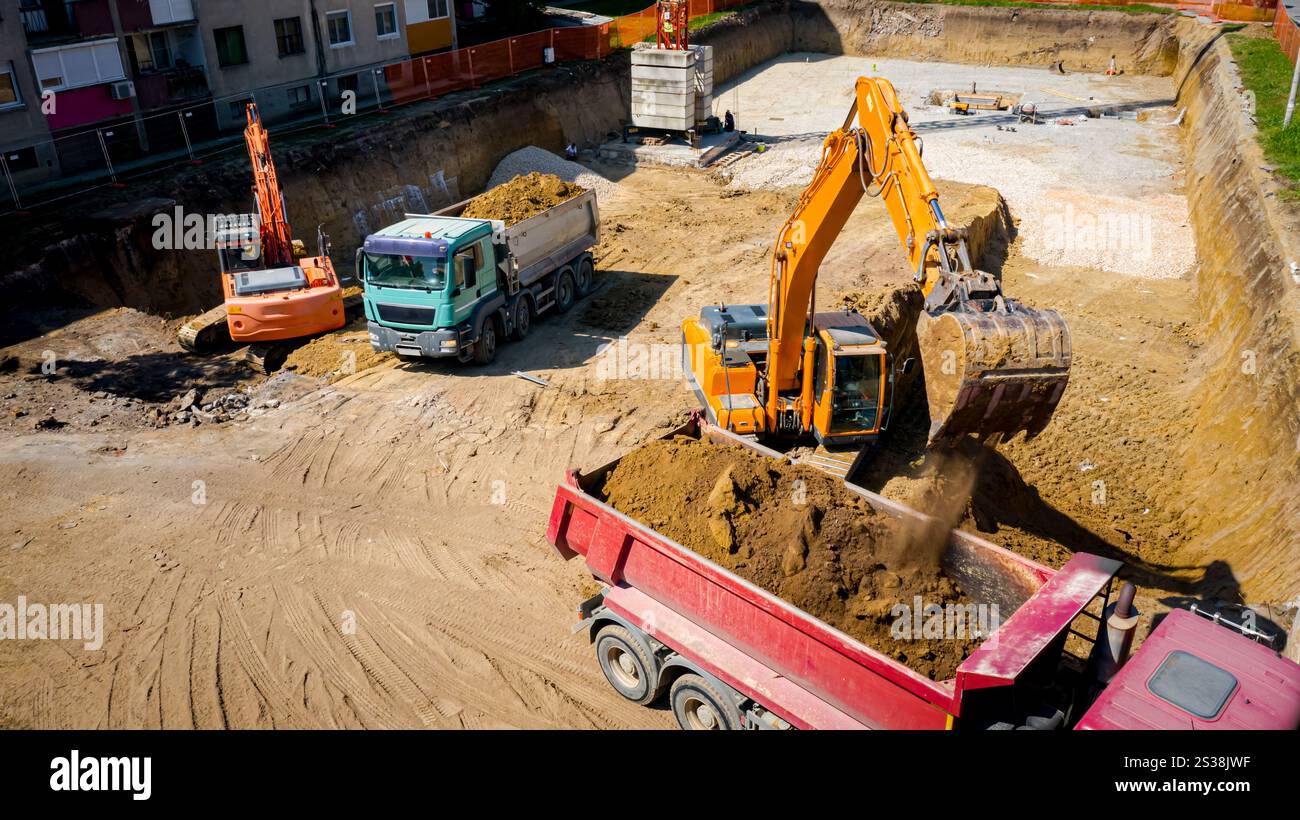 Above view on two big excavators as they digging, excavating foundation for new residential ...