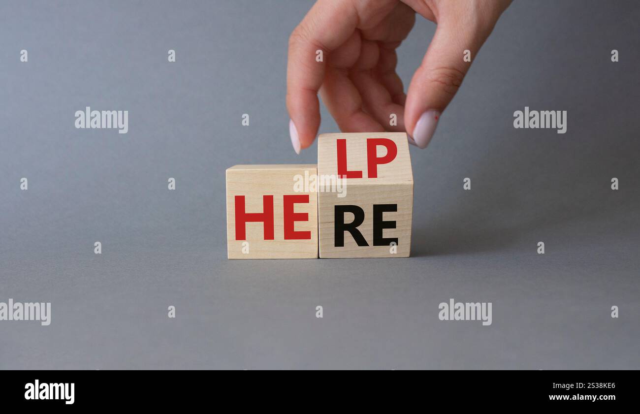 Help is here symbol. Businessman hand Turnes cube and changes word Here ...