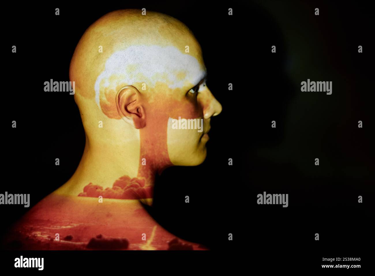Profile of emotionless bald man with image of cloud from nuclear ...