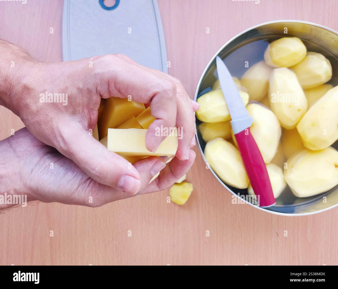Man holding and peeling potato. Hands cutting potatoes at kitchen to ...
