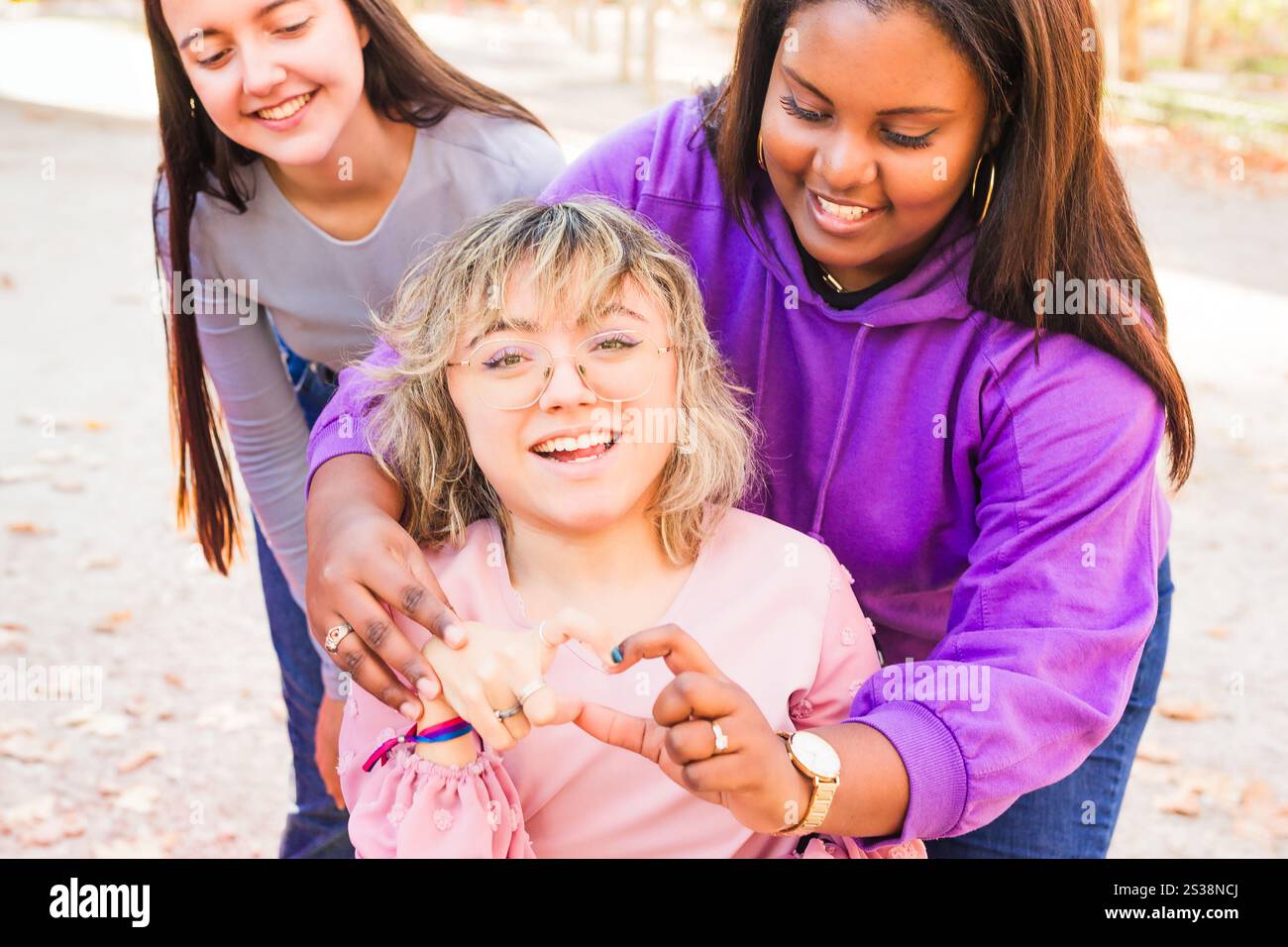 Women with cerebral palsy making heart shape with hands, embracing ...