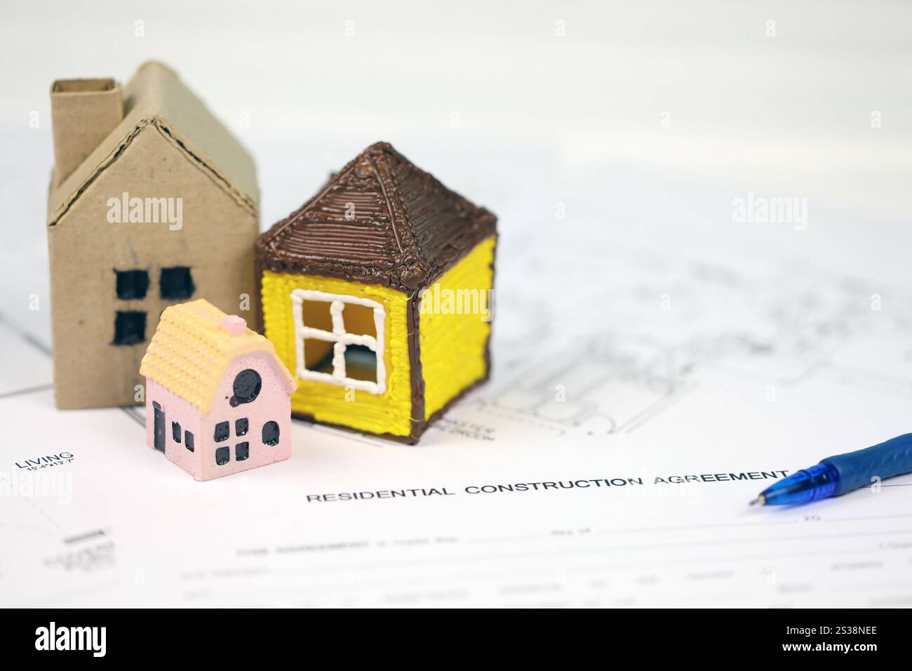 Residential construction agreement ready to sign with small toy houses ...