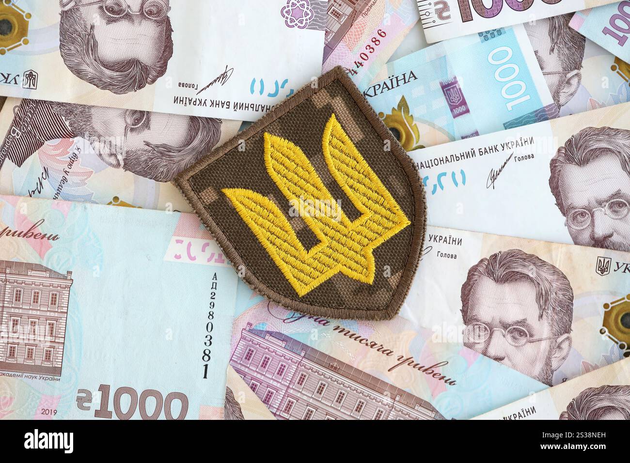 Ukrainian military symbol and hryvnia bills. Payments to soldiers of ...