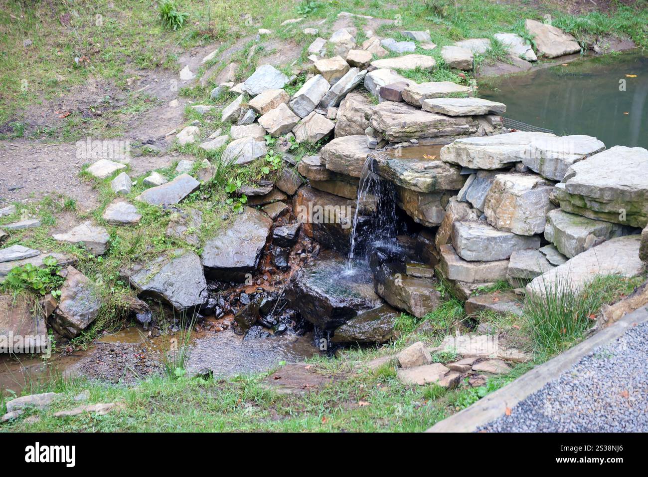 Close up of a small waterfall spilling over moss covered rocks in ...