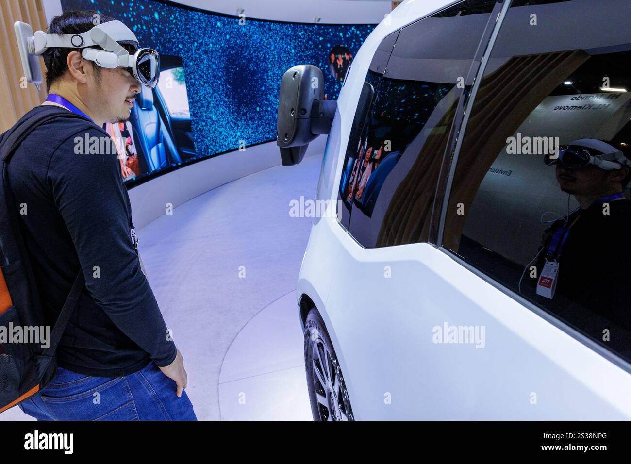 An attendee looks at the Zeekr RT through augmented reality glasses ...