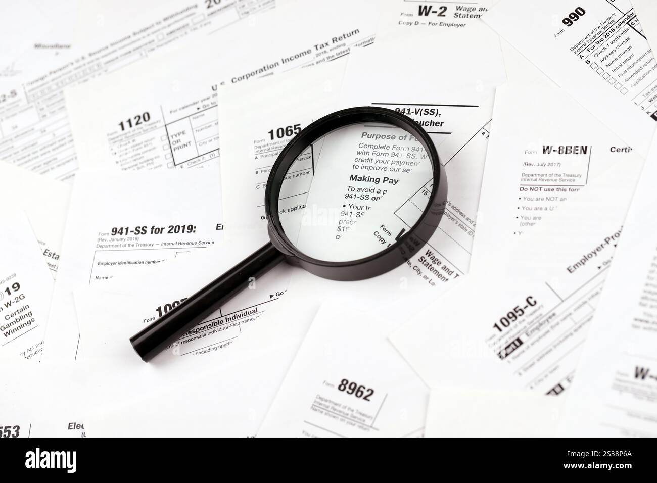 Magnifying glass lying over heap of paper documents. Investigation and ...