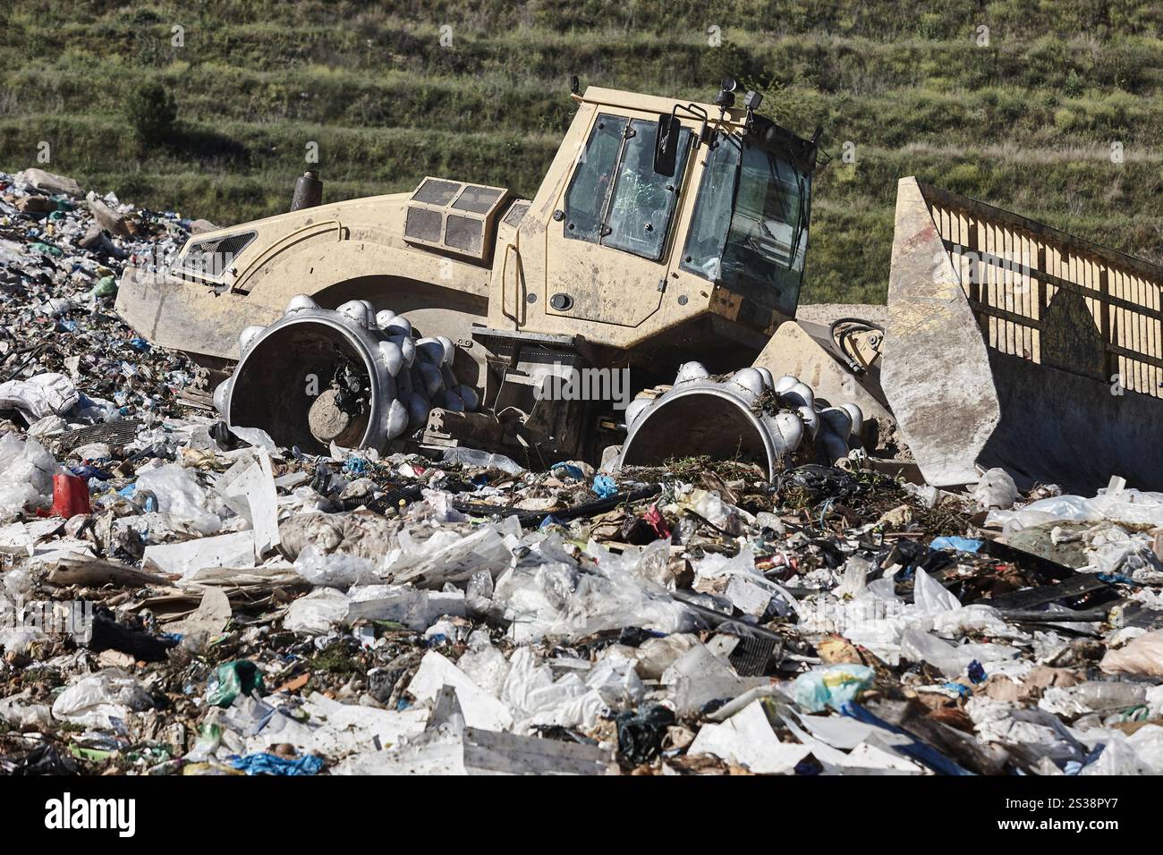 Heavy machinery shredding garbage in an open air landfill. Waste Stock ...
