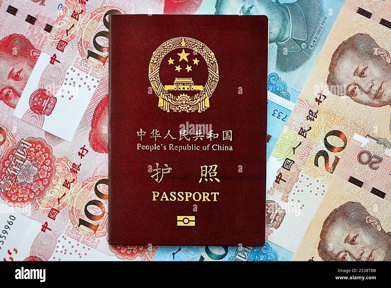 Red passport of People Republic of China and chinese yuan money bills. PRC chinese passport on ...