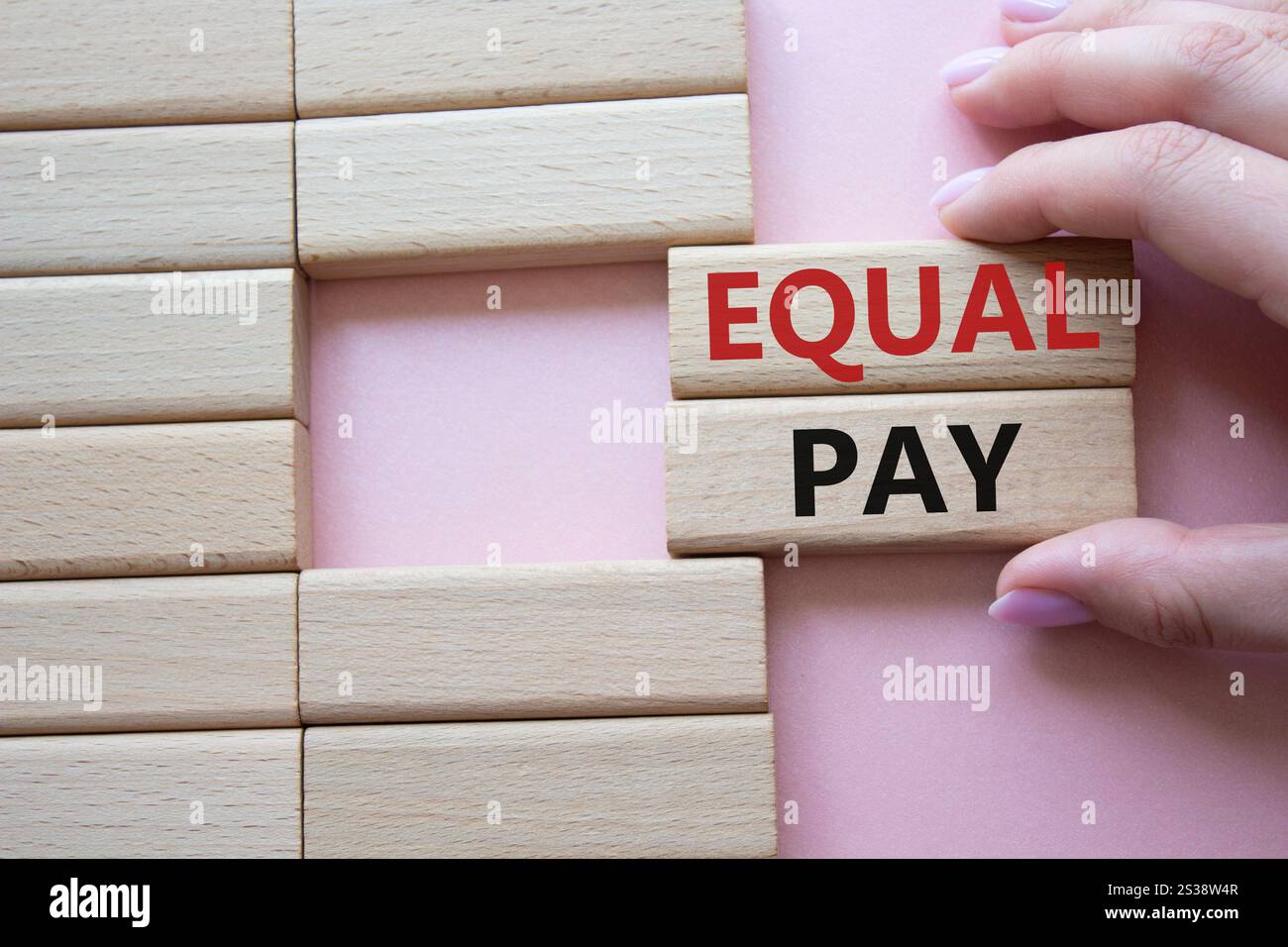 Equal Pay symbol. Wooden blocks with words Equal Pay. Beautiful pink ...