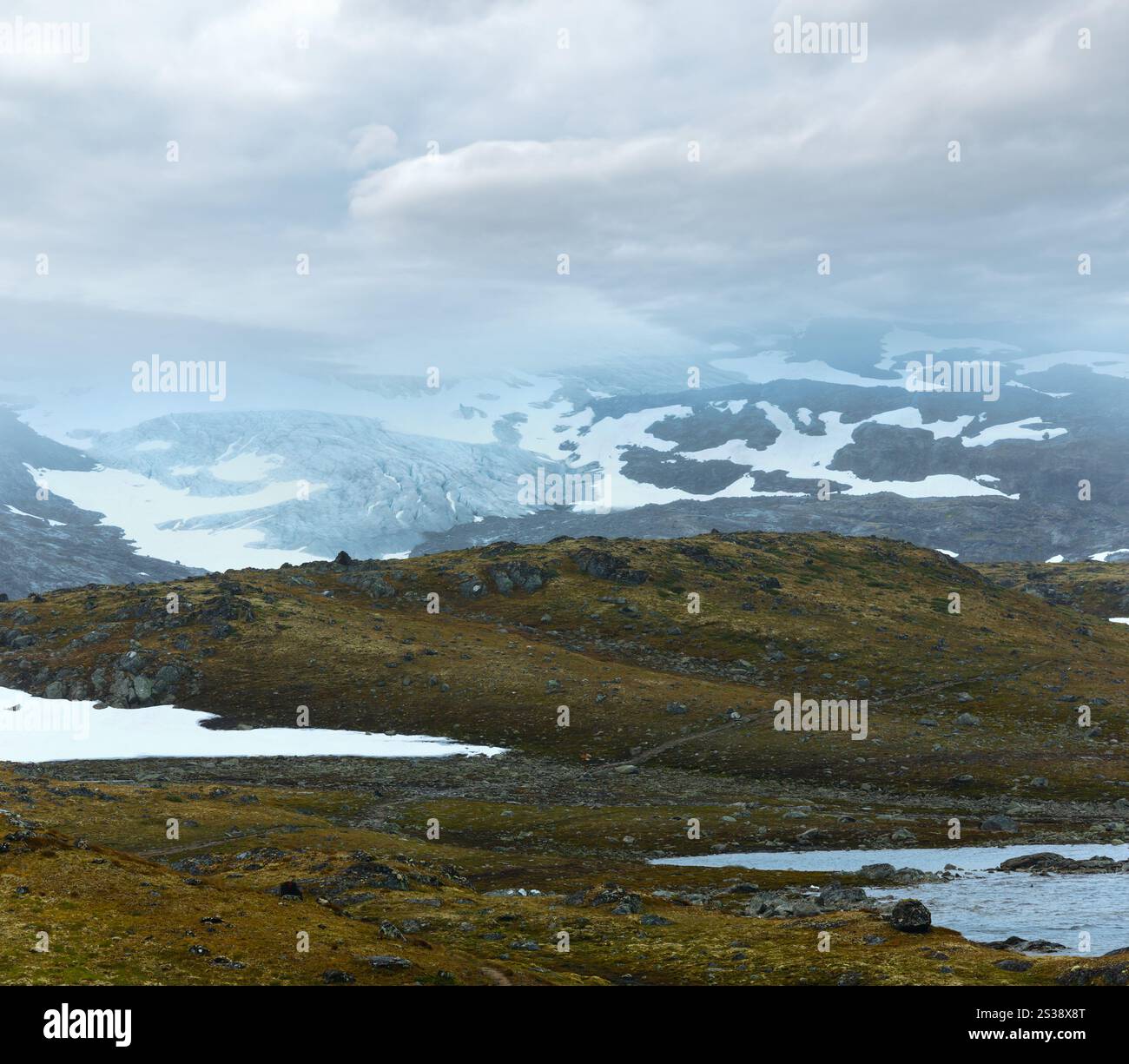 Dense fog and summer mountain landscape with lake and snow (Norway, not ...