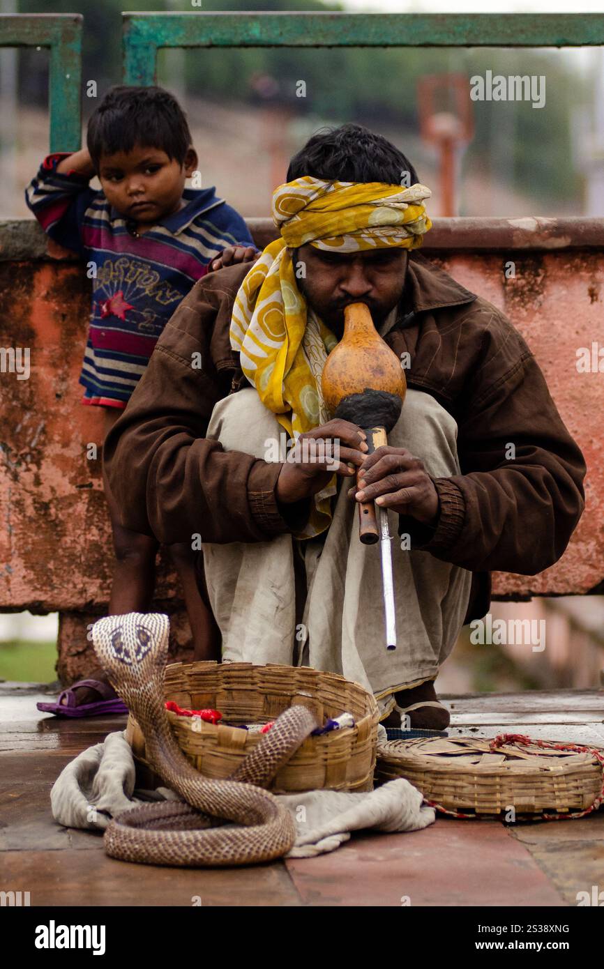 Street performer playing music with a flute while a child looks on in a ...