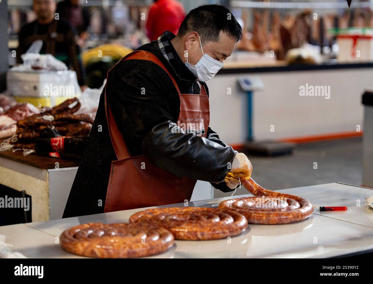 YICHANG, CHINA - JANUARY 9, 2025 - A worker dries pork sausage at a ...