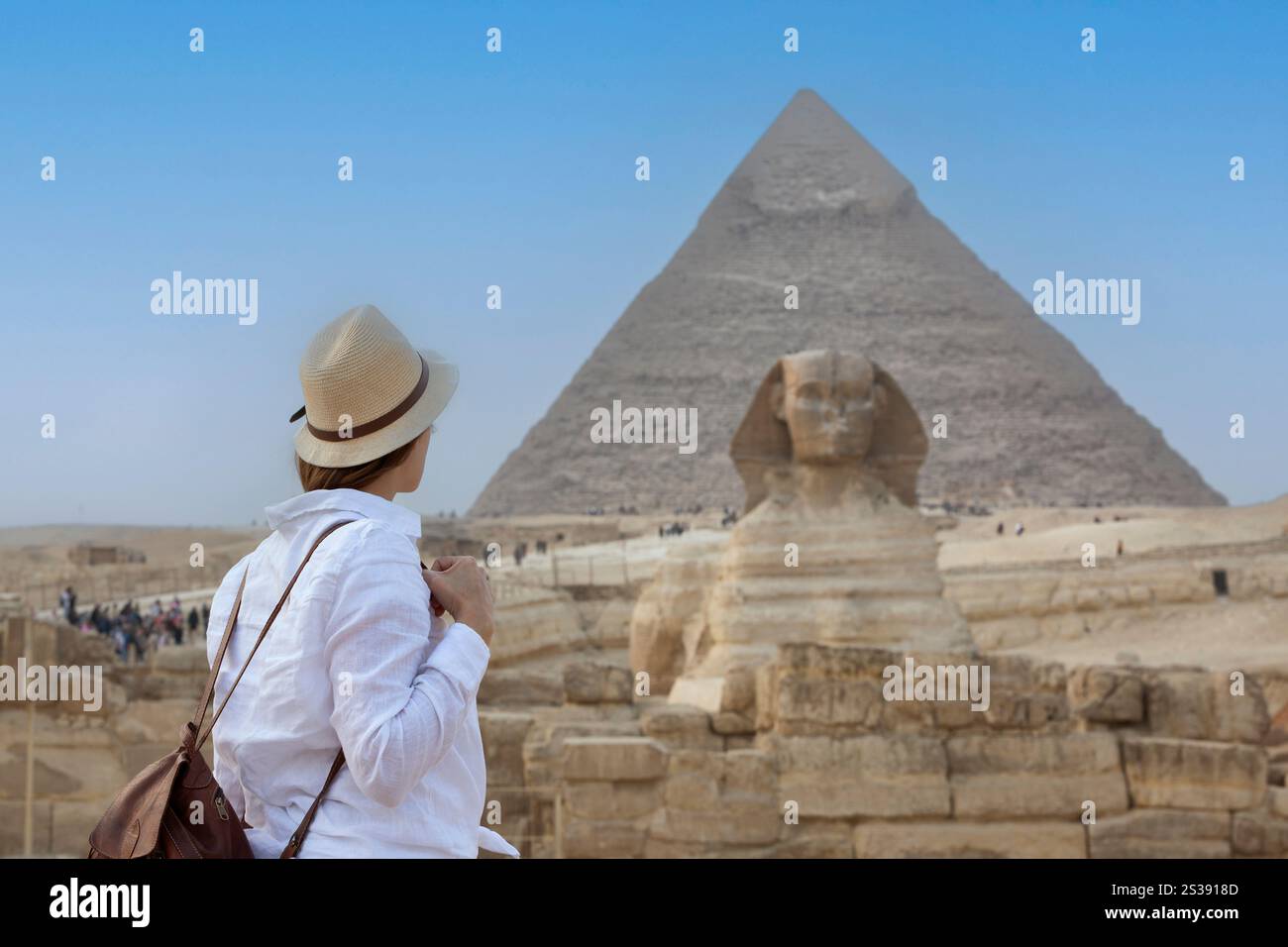 Back view of a woman wearing a hat, looking at the great pyramids in ...