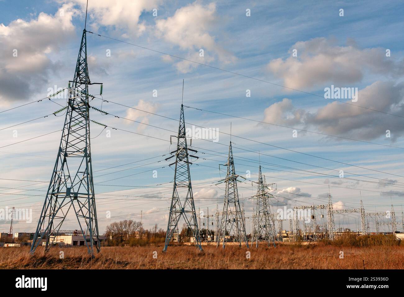 Power transmission pylons spanning across an open field under a clear ...