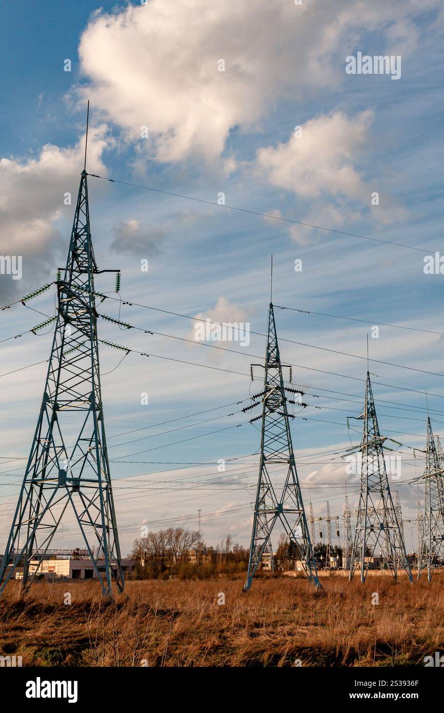 Power transmission pylons spanning across an open field under a clear ...