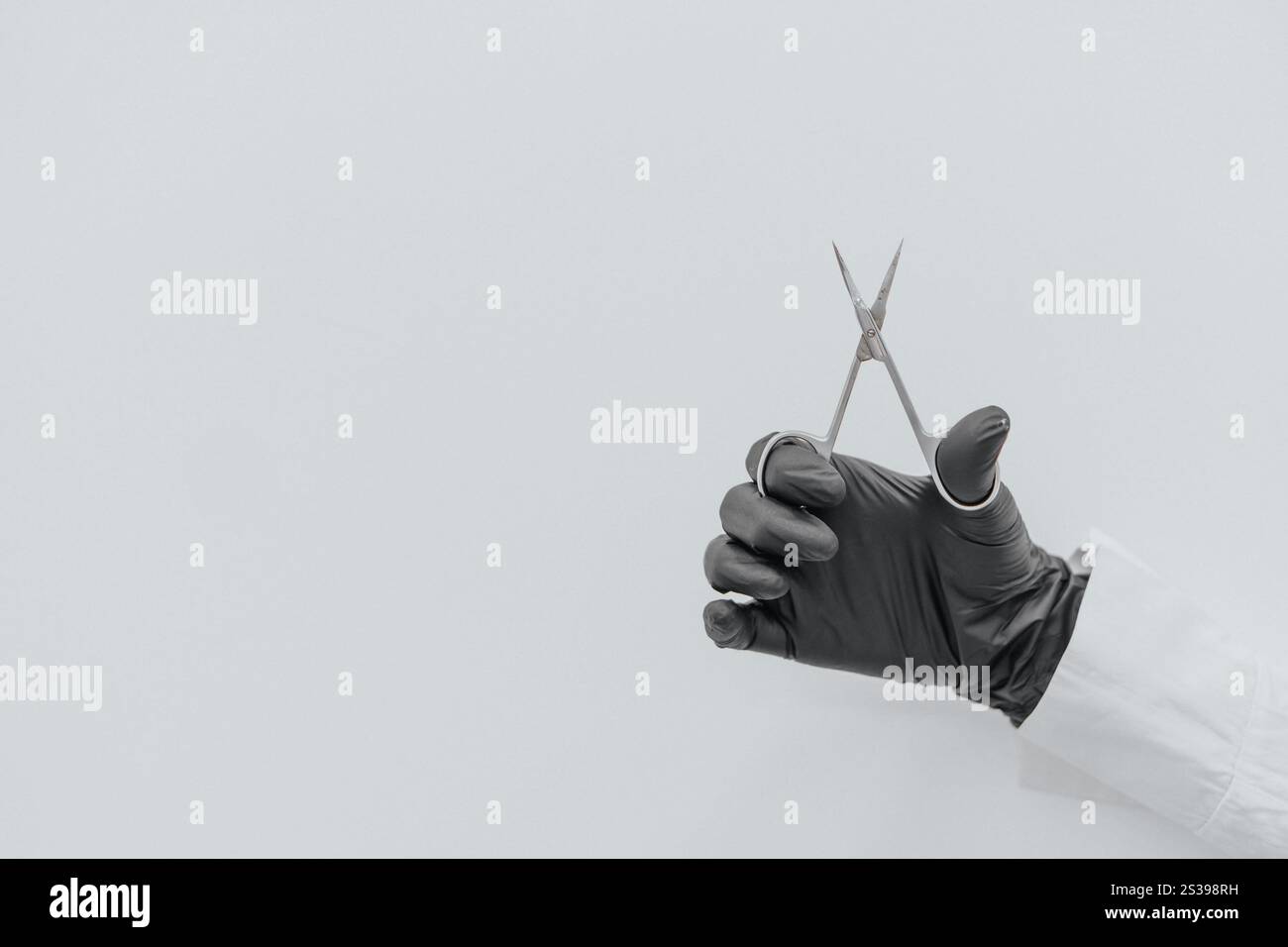 Black gloved hand holding precision scissors Stock Photo - Alamy