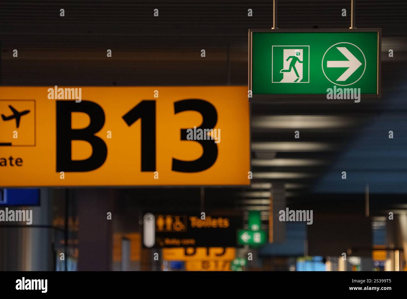 Yellow plane boarding gate sign and green exit sign Stock Photo - Alamy