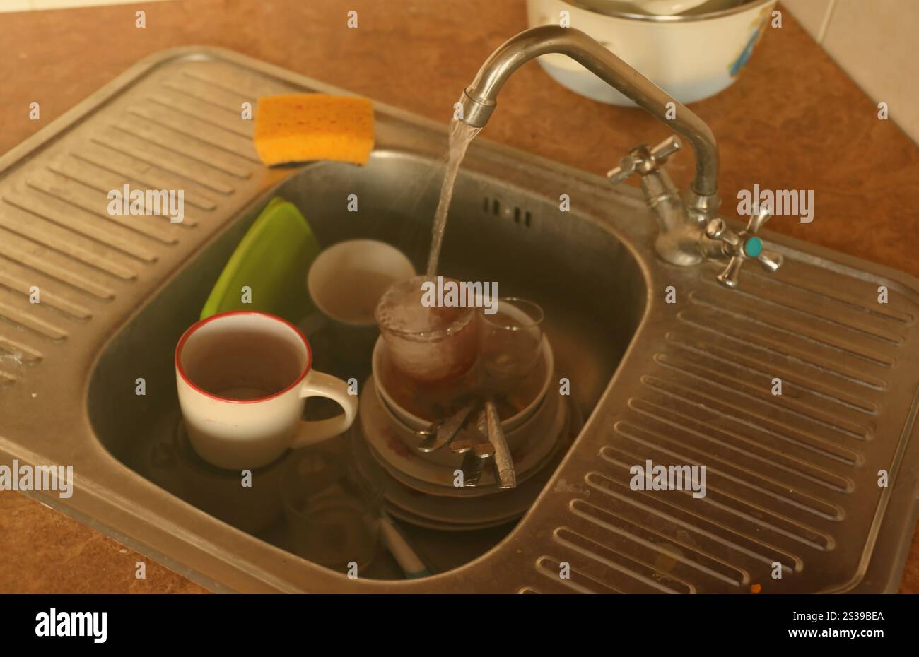 Stack of dirty dishes with food leftovers in the kitchen sink. Unwashed ...