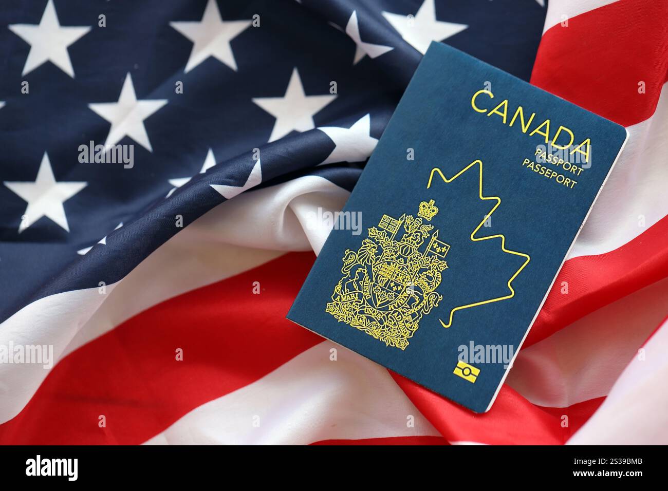 Canadian passport on United States national flag background close up ...