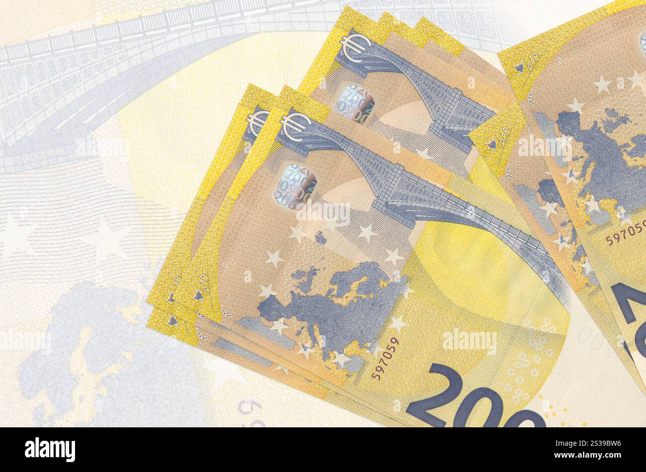 200 euro bills lies in stack on background of big semi-transparent banknote. Abstract ...