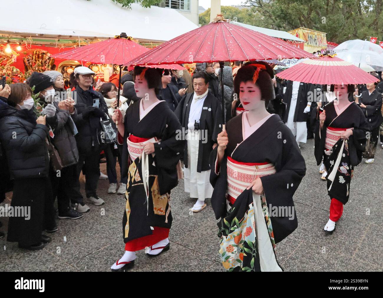 Some Geisha girls parade along the approach to the shrine at Toka Ebisu Shrine in Hakata Ward ...