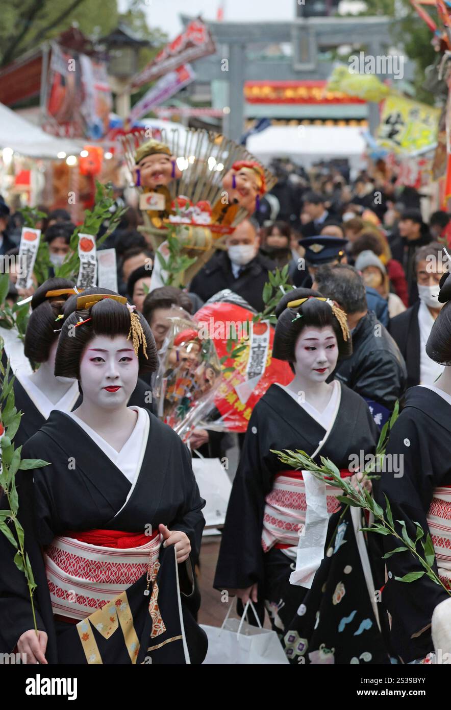 Some Geisha girls parade along the approach to the shrine at Toka Ebisu ...