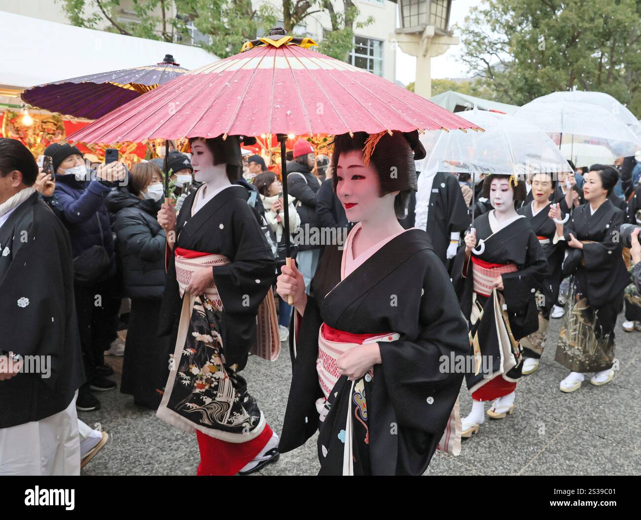 Some Geisha girls parade along the approach to the shrine at Toka Ebisu Shrine in Hakata Ward ...