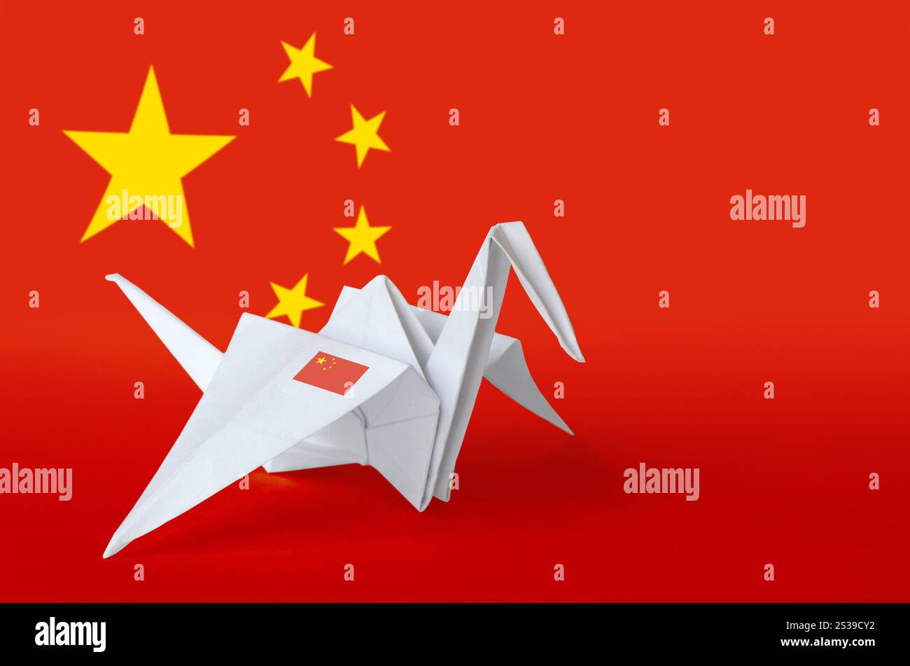 China flag depicted on paper origami crane wing. Oriental handmade arts ...