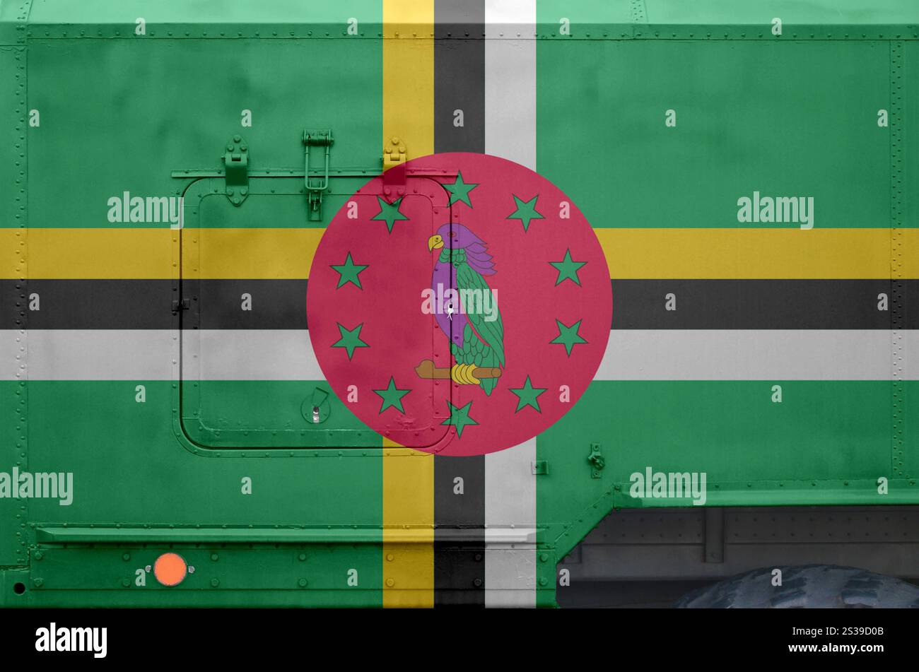 Dominica flag depicted on side part of military armored truck close up ...