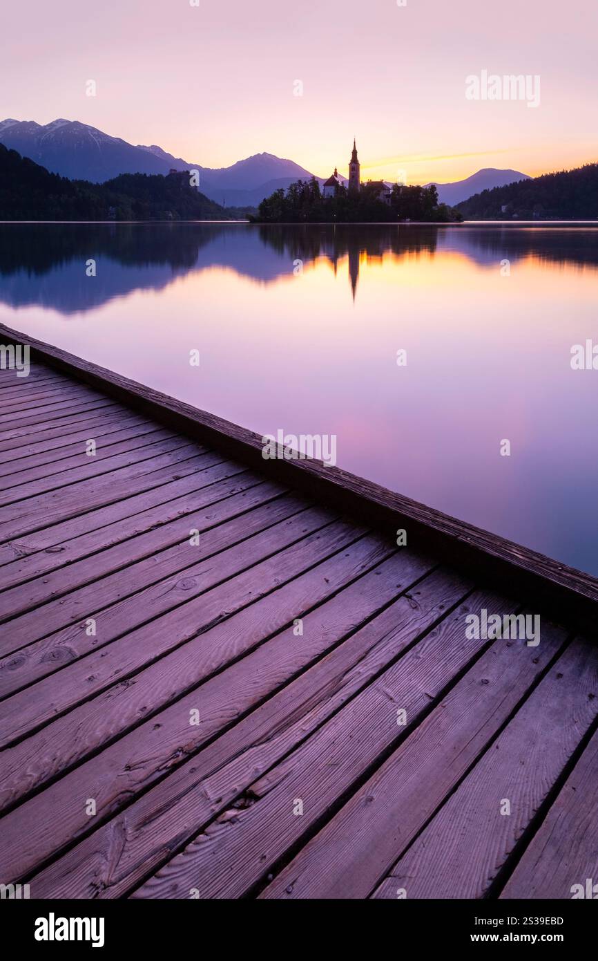 View of the wooden walkway around lake Bled at dawn in spring with the ...