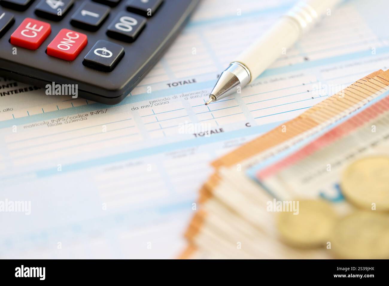 Filling italian tax form process with pen, calculator and euro money ...