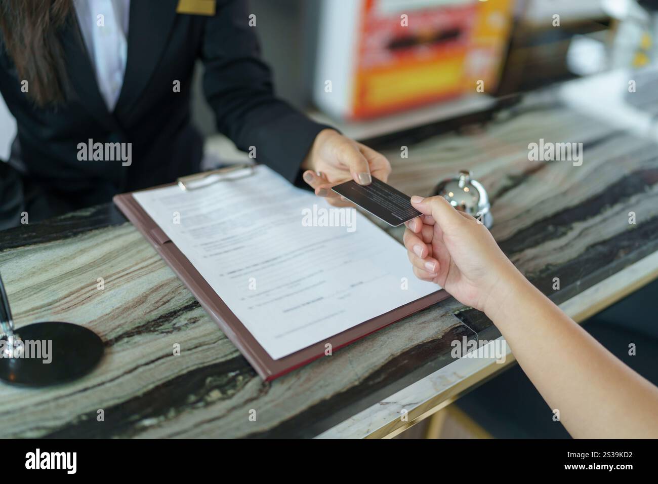 Hotel receptionist in uniforms Concierge giving the key doing check-in ...
