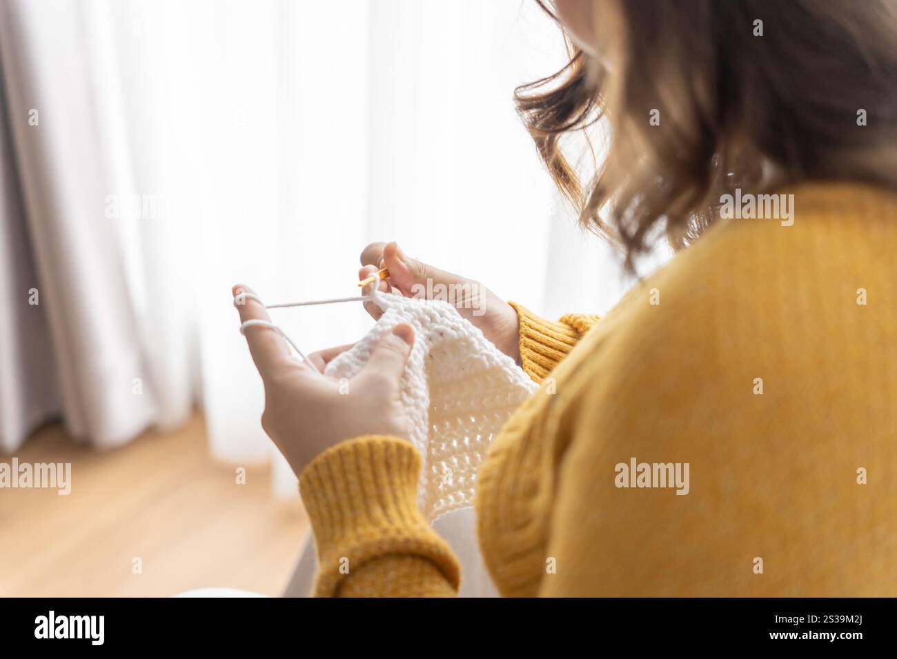 Pregnant asian woman preparing for baby knitting baby winter clothes ...