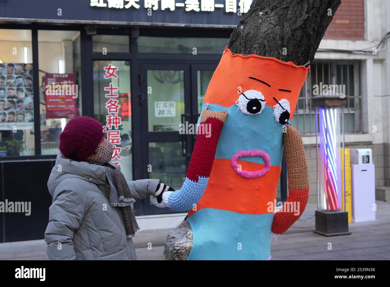 Trees on the street are put on brightly colored "sweaters" for winter ...