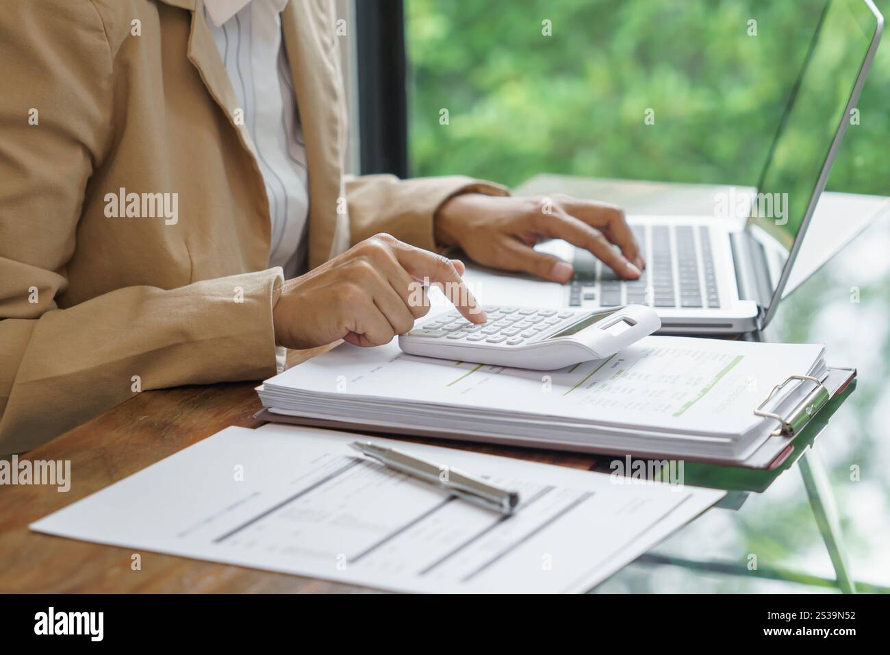 Business woman calculating financial statement on calculator income tax ...